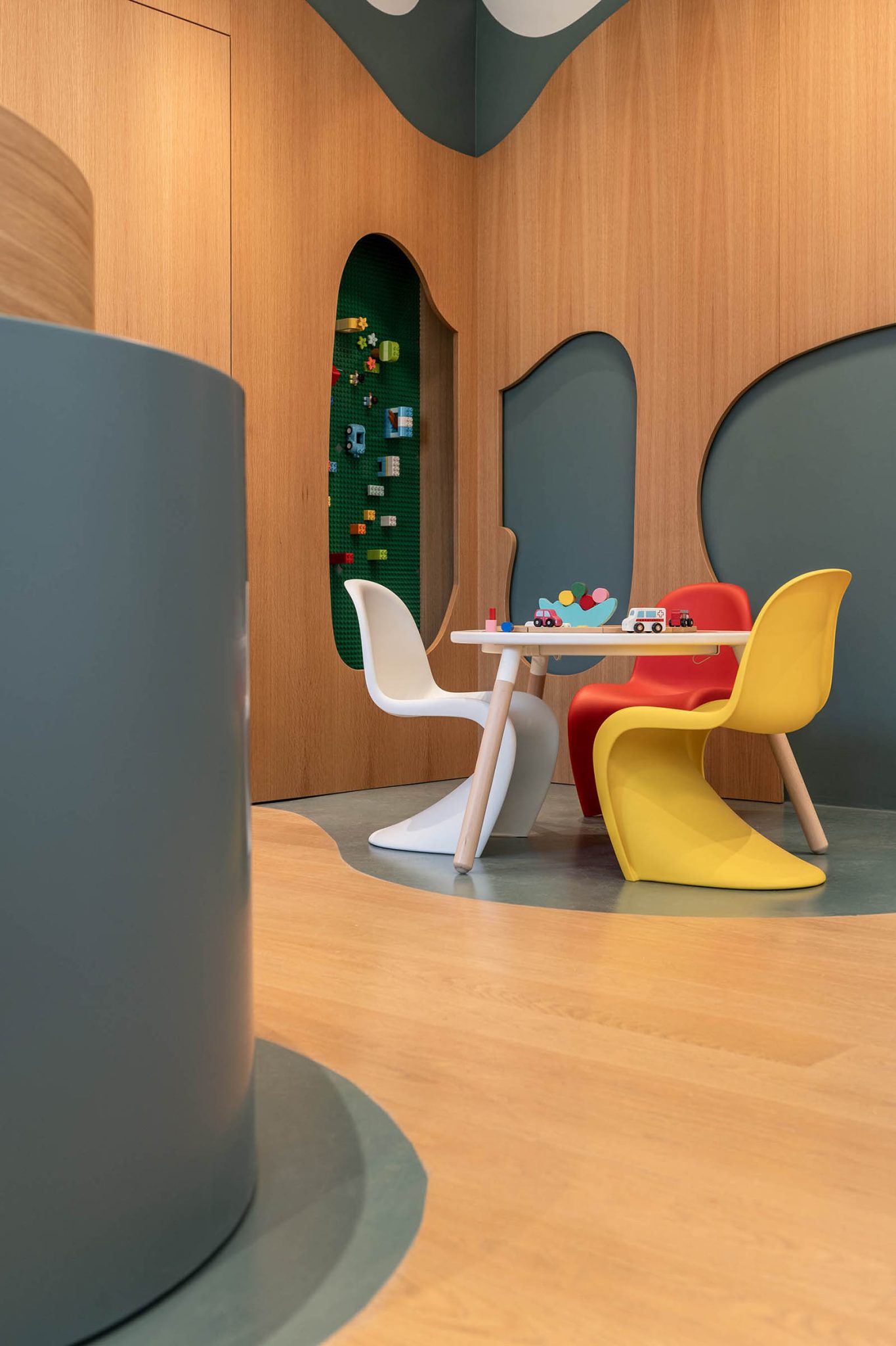 Close up of play area with sculptural chairs and built in green LEGO ...